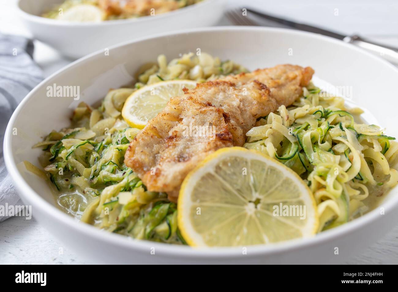 Low carb fish fillet with creamy zucchi noodles on a plate Stock Photo ...