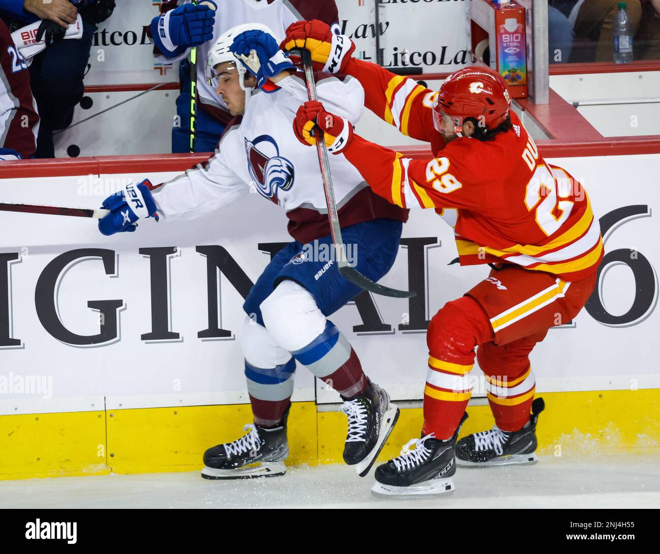 Colorado Avalanche forward Alex Newhook, left, is checked by Calgary ...