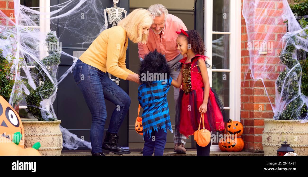 Grandchildren Dressing Up And Visiting Grandparent's House Trick Or ...