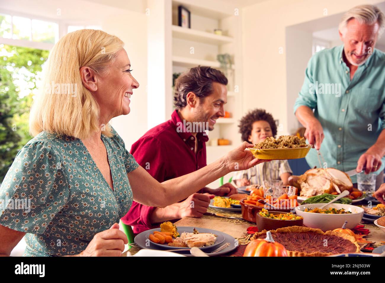 Grandfather Serving As Multi-Generation Family Celebrating Thanksgiving ...