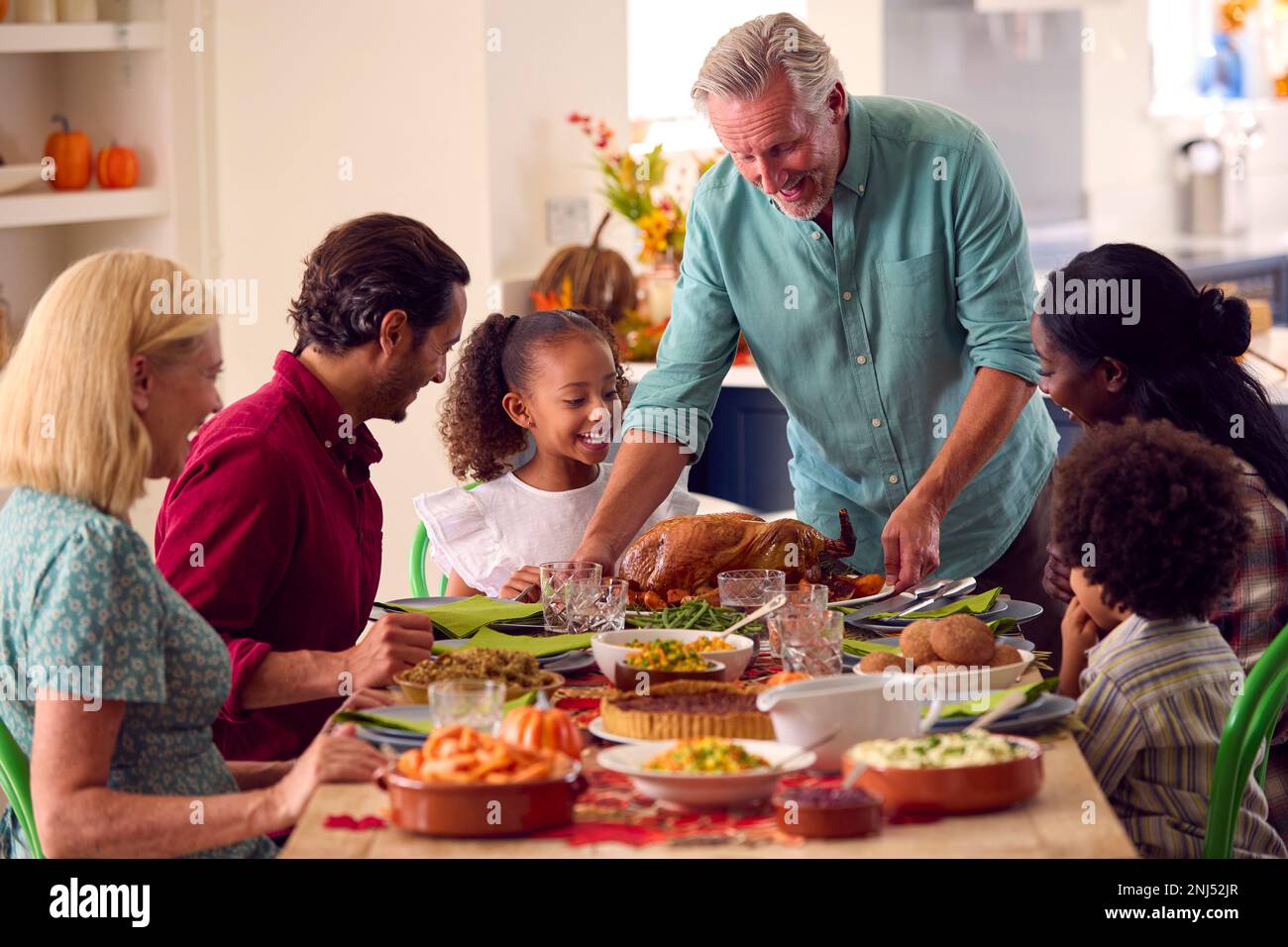 Grandfather Serving As Multi-Generation Family Celebrating Thanksgiving ...