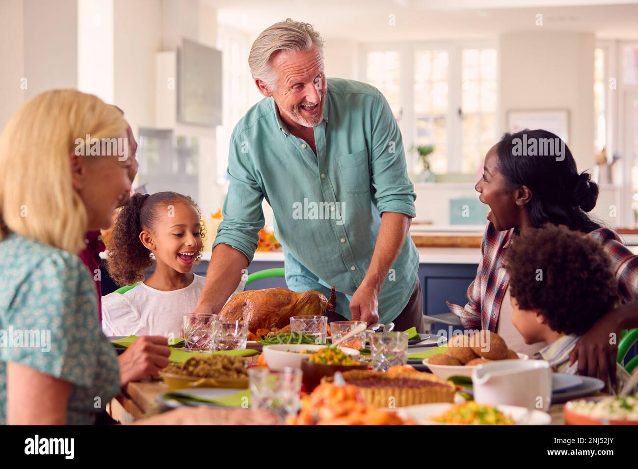 Grandfather Serving As Multi-Generation Family Celebrating Thanksgiving ...