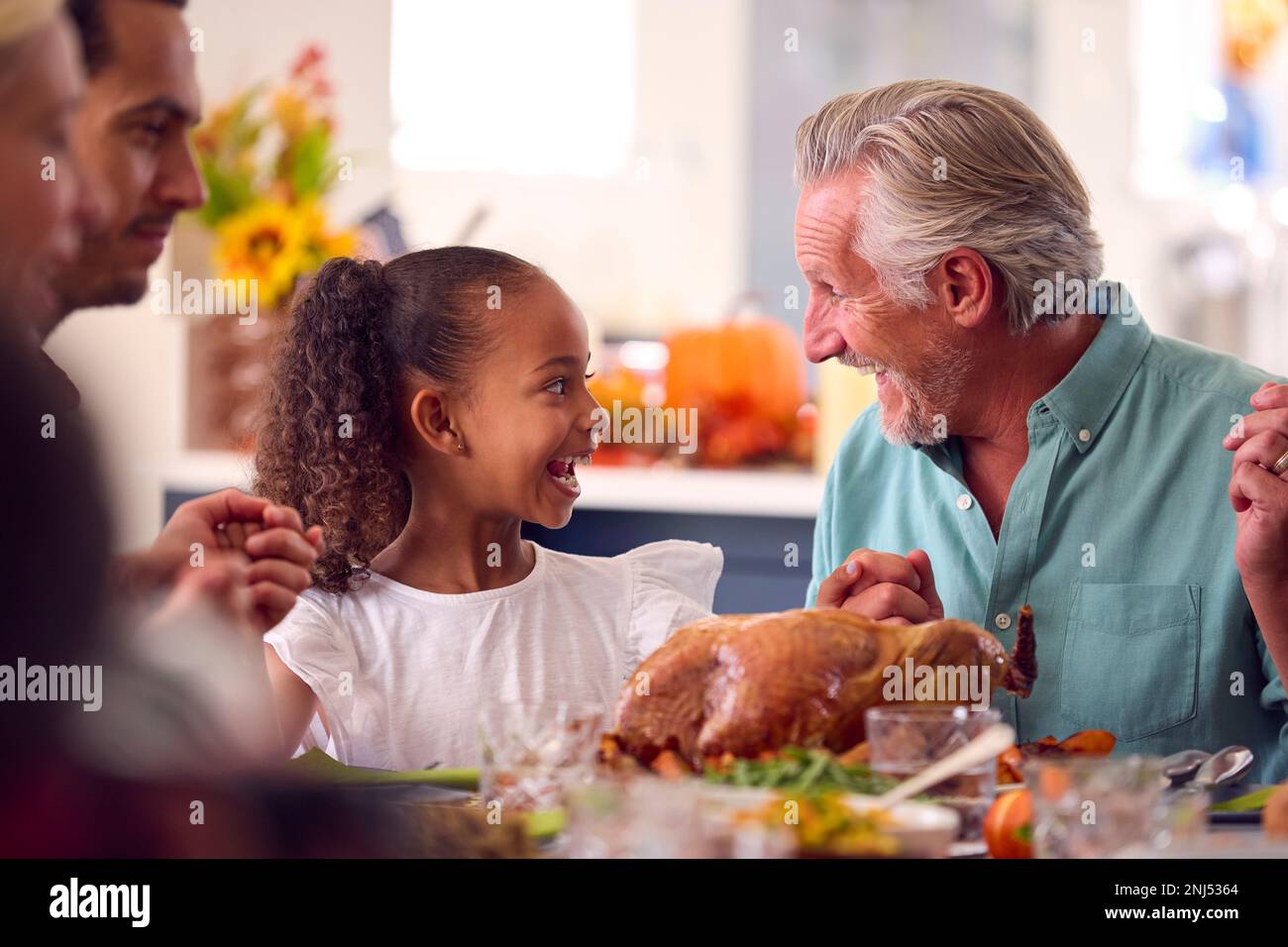 Multi-Generation Family Celebrating Thanksgiving At Home Eating Meal ...