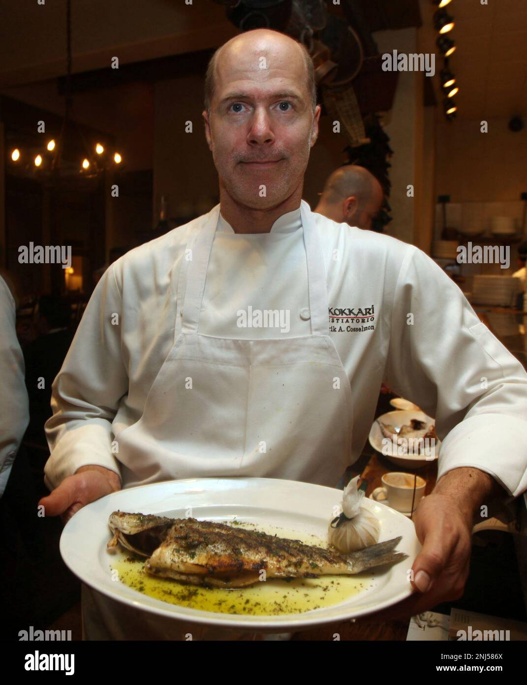 Executive chef, Erik Cosselmon holds a dish of whole grilled Lavraki, a ...