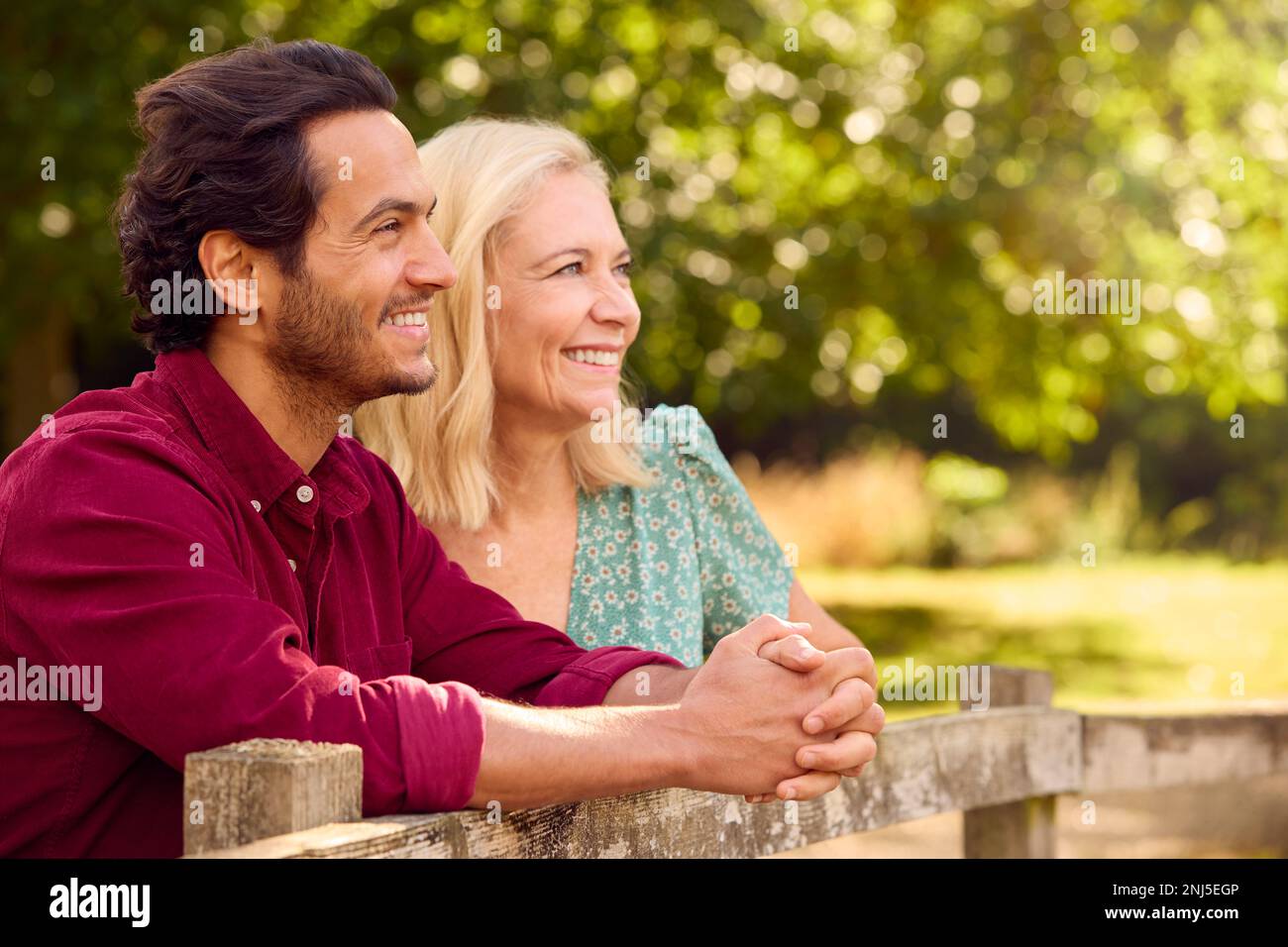 Mature Mother With Mixed Race Adult Son Leaning On Fence Walking In