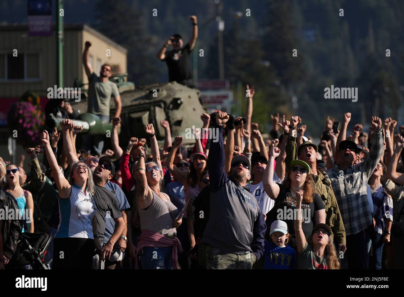 People shout and raise their fists as a drone is used to record video ...