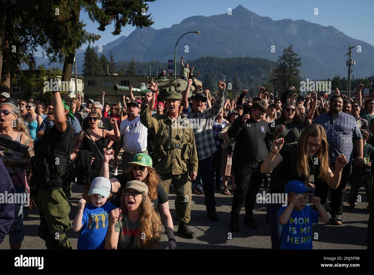 People shout and raise their fists as a drone is used to record video ...