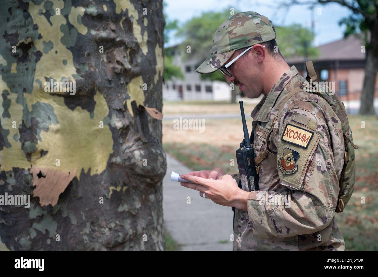 U.S. Air Force Senior Airman Anthony Walker uses a map and a compass to ...