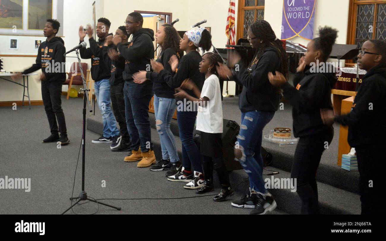 Members of the Redeemed Fellowship youth group clap their hands and ...