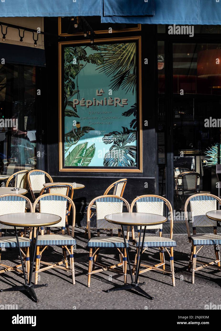 Cafe culture. The La Pepiniere cafe in Paris. Blue awnings above, cafe ...