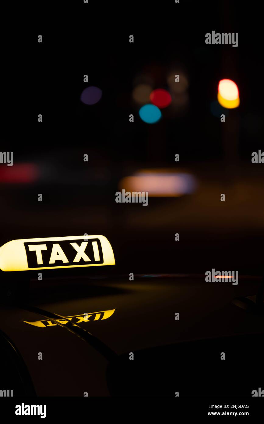 A yellow taxi car parked on a city street at night Stock Photo - Alamy