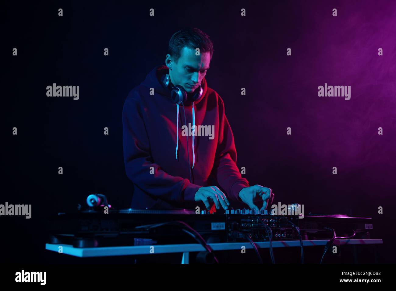 Hip hop party DJ plays vinyl music set with sound mixer and turntables ...