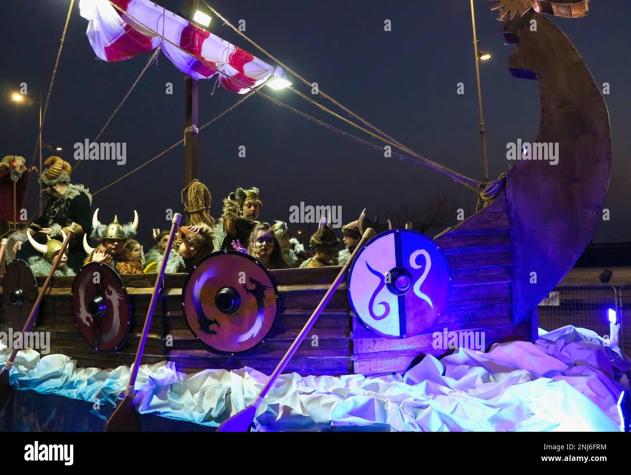 Evening carnival parade with children in a viking boat on a float in ...