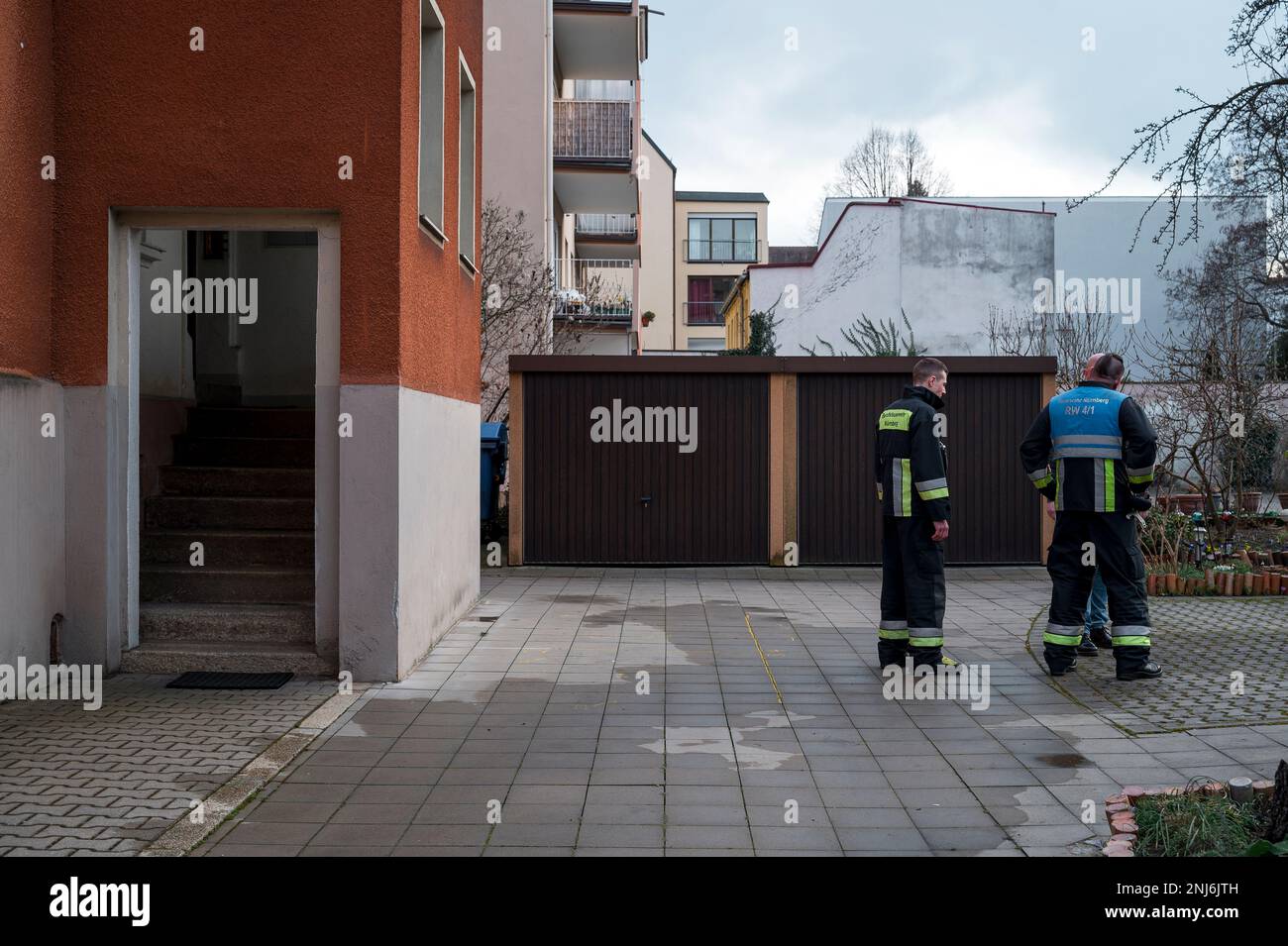 Nuremberg, Germany. 22nd Feb, 2023. Police and firefighters stand on the property of the house ...