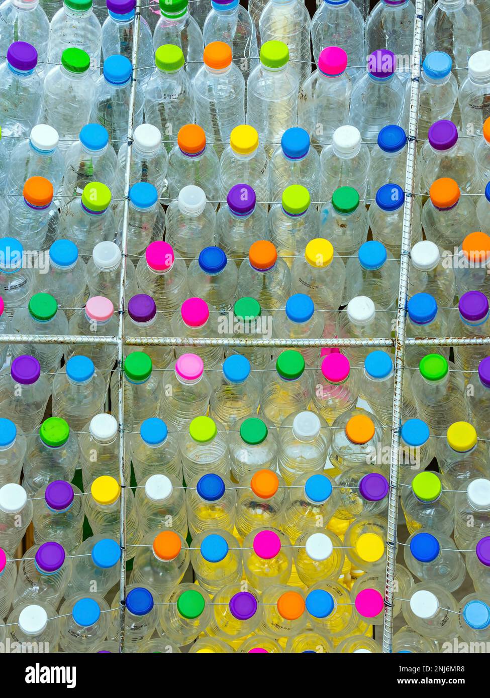 Beautiful wall made of multi colored recycled plastic bottles. Bottle ...