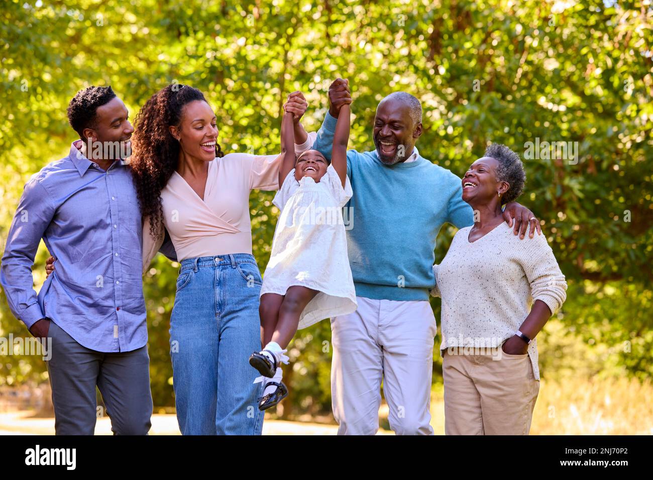 Multi-Generation Family Enjoying Walk In Countryside Together Swinging ...