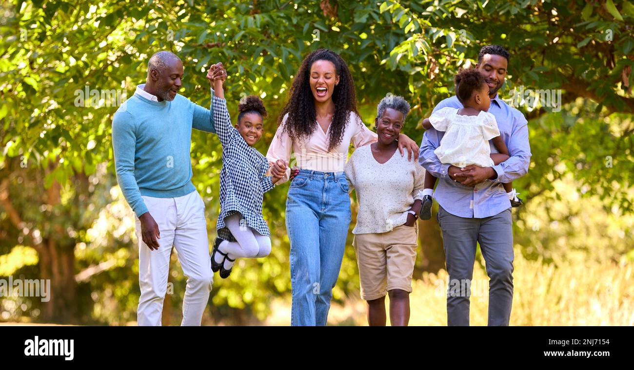 Multi-Generation Family Enjoying Walk In Countryside Together Swinging ...