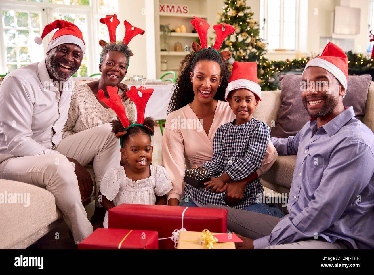 Multi-Generation Family Celebrate Christmas At Home Wearing Santa Hats ...