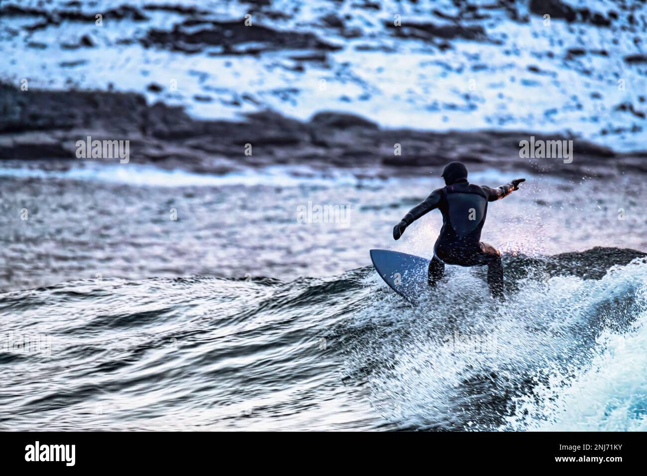 riding the ocean waves at sunset Stock Photo - Alamy