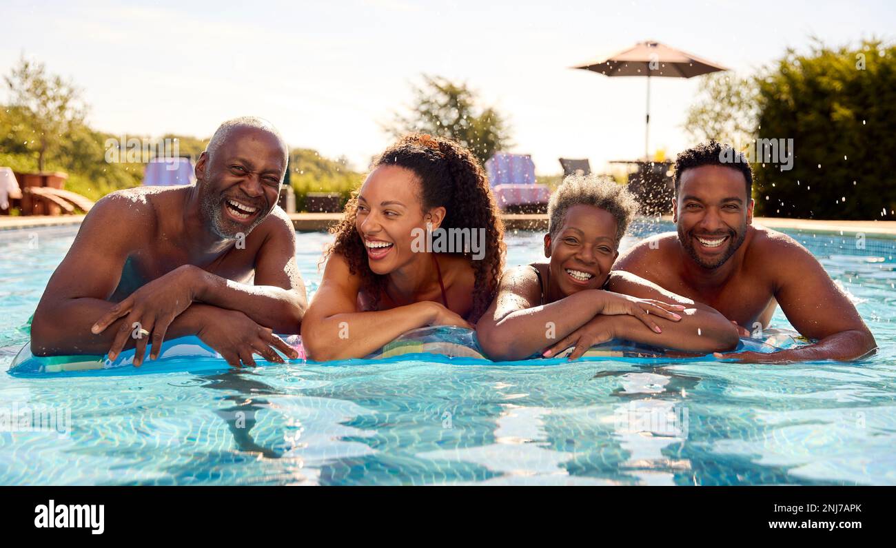 Multi-Generation Family With Adult Offspring On Summer Holiday On Inflatable In Swimming Pool ...