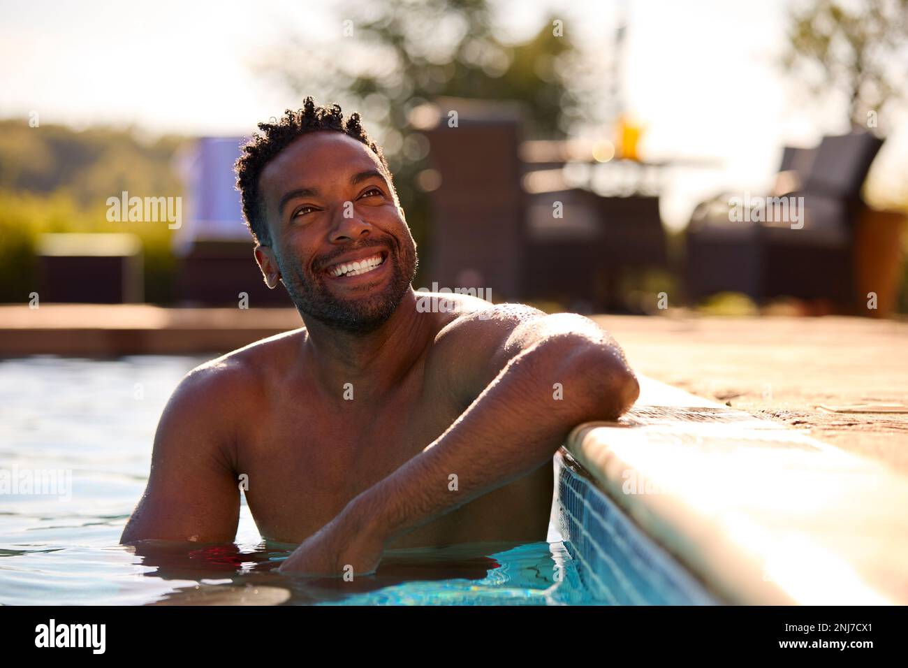 Smiling Man On Summer Holiday Relaxing In Swimming Pool Stock Photo - Alamy