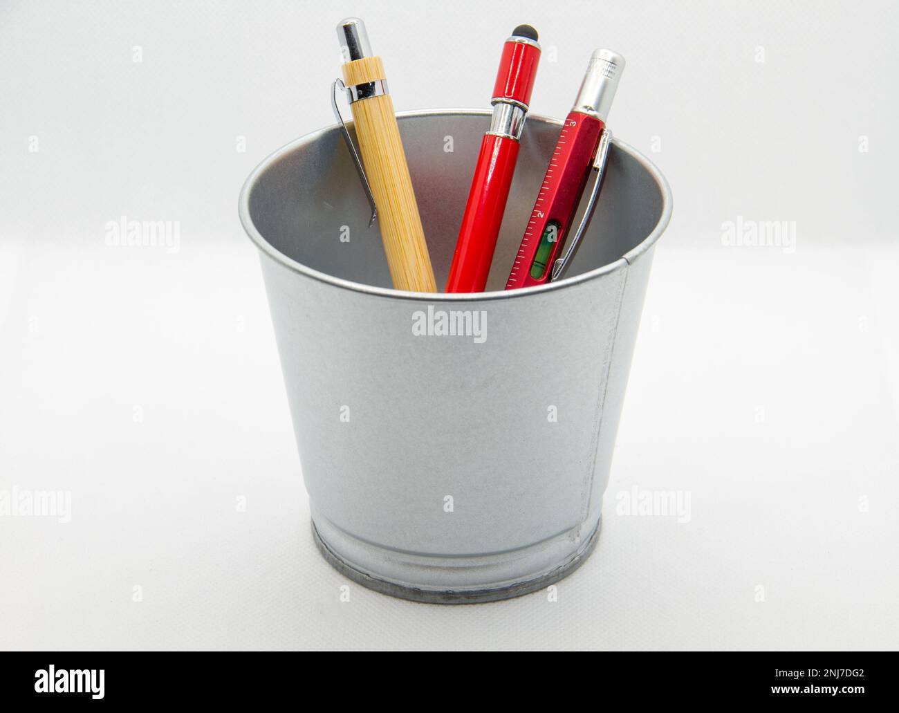 Three pens in a metallic bucket isolated on white background Stock ...