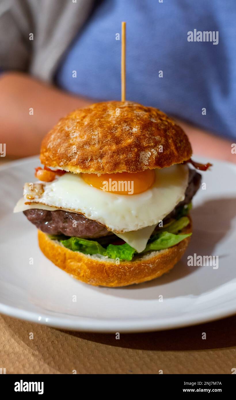 Tasty burger made with white crispy ban, beef burger, egg, green ...