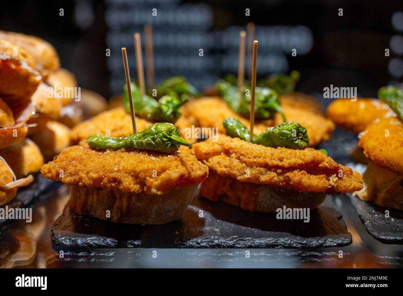 Typical snack of Basque Country, pinchos or pinxtos skewers with small ...