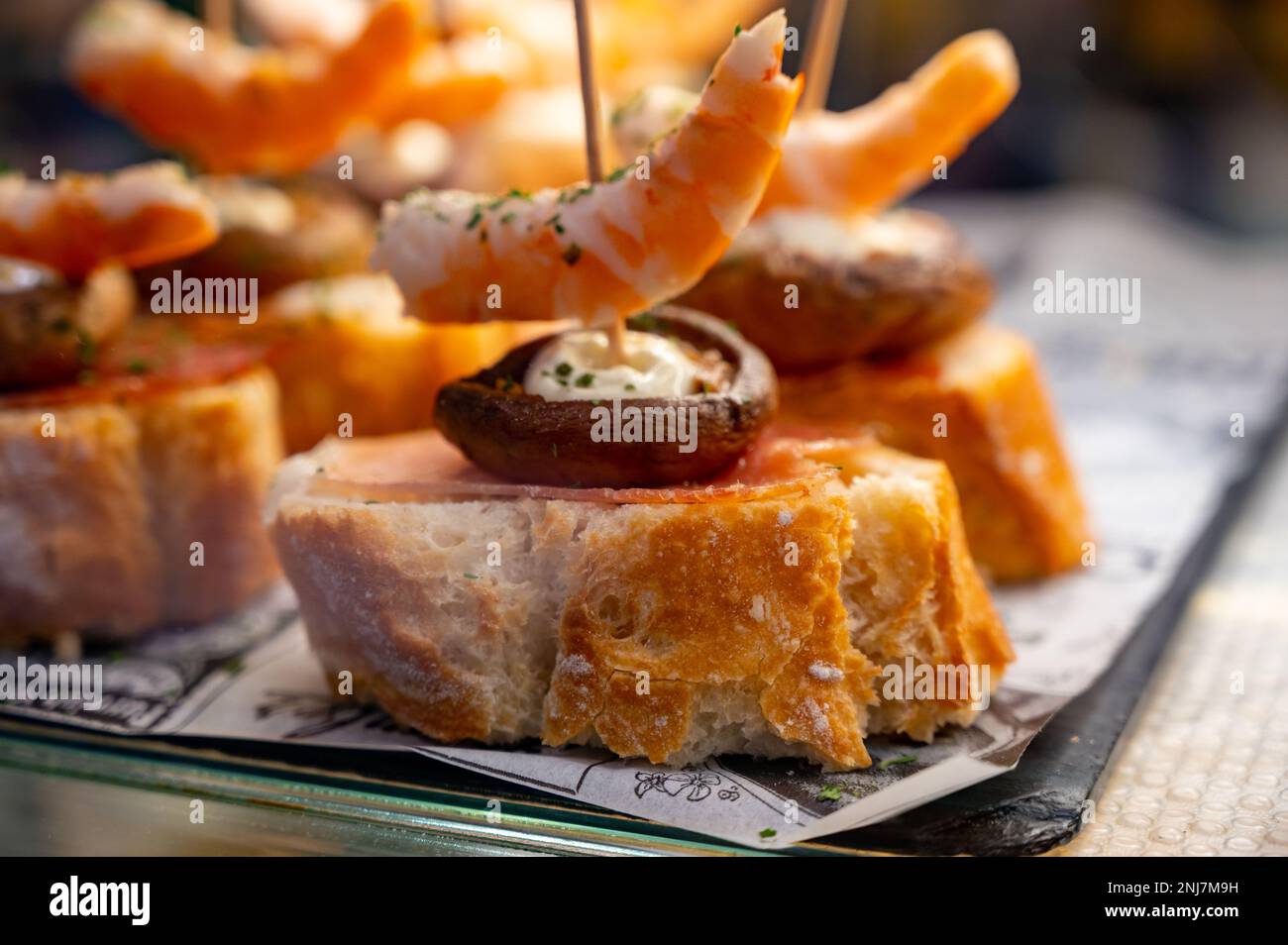 Typical snack of Basque Country, pinchos or pinxtos skewers with small ...