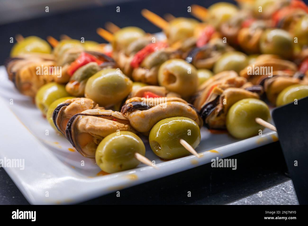 Typical snack of Basque Country, pinchos or pinxtos skewers with small ...