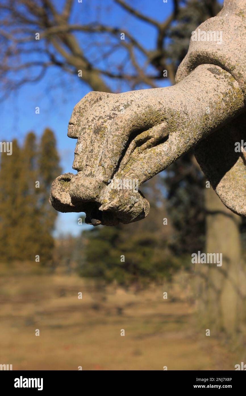 The statue of a stone hand holding a beautiful flower Stock Photo - Alamy
