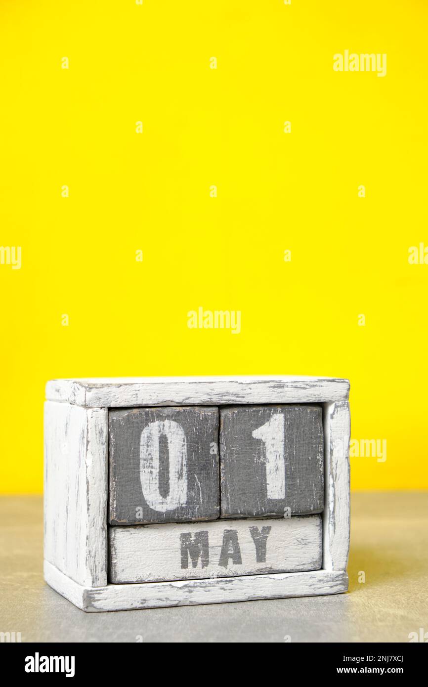May 1, Wooden desktop calendar yellow background.Spring month depicted ...