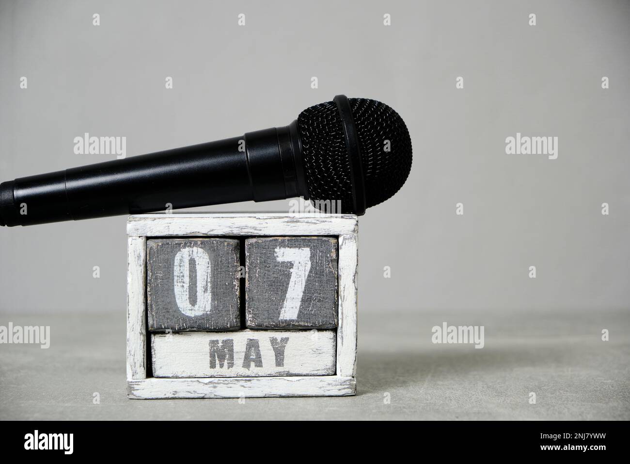 May 07, wooden calendar and black microphone gray background.Concept ...