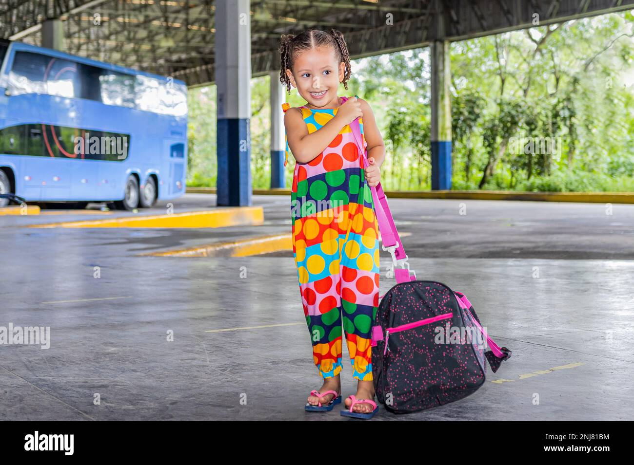 Little Latina And Brazilian Girl With A Big Bag Waiting For A Bus At