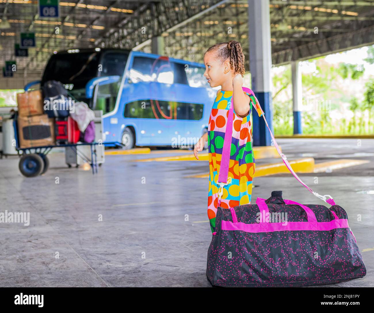 Little Latina And Brazilian Girl With A Big Bag Waiting For A Bus At