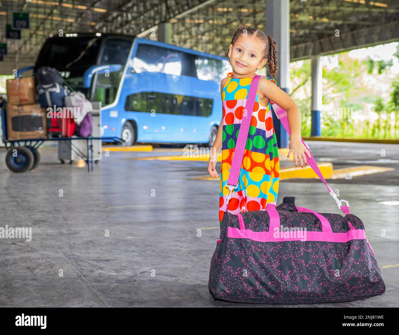 Little latina and brazilian girl with a big bag waiting for a bus at ...
