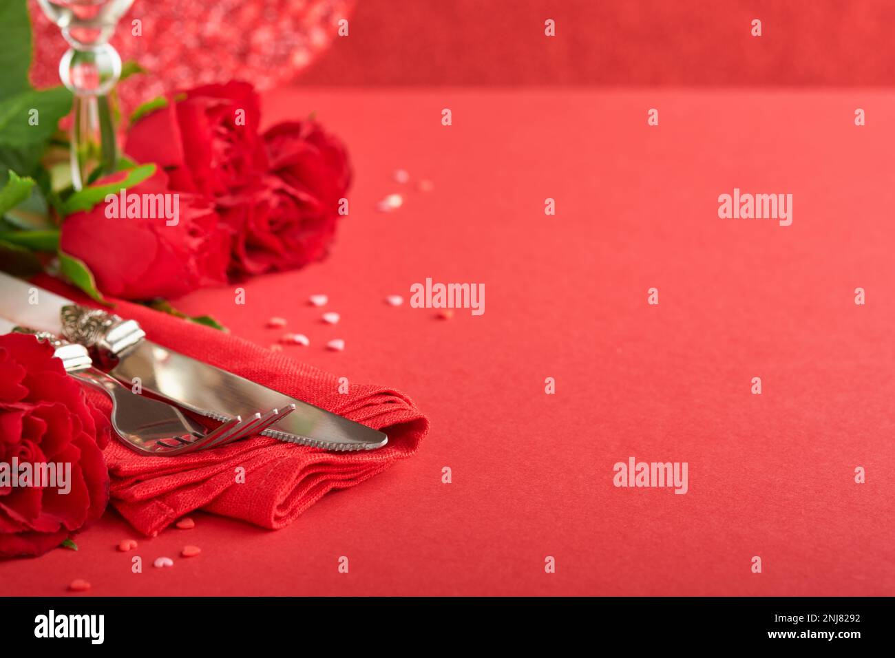 Romantic dinner concept. Romantic table setting, silverware, wine glasses, gift box, roses and ...