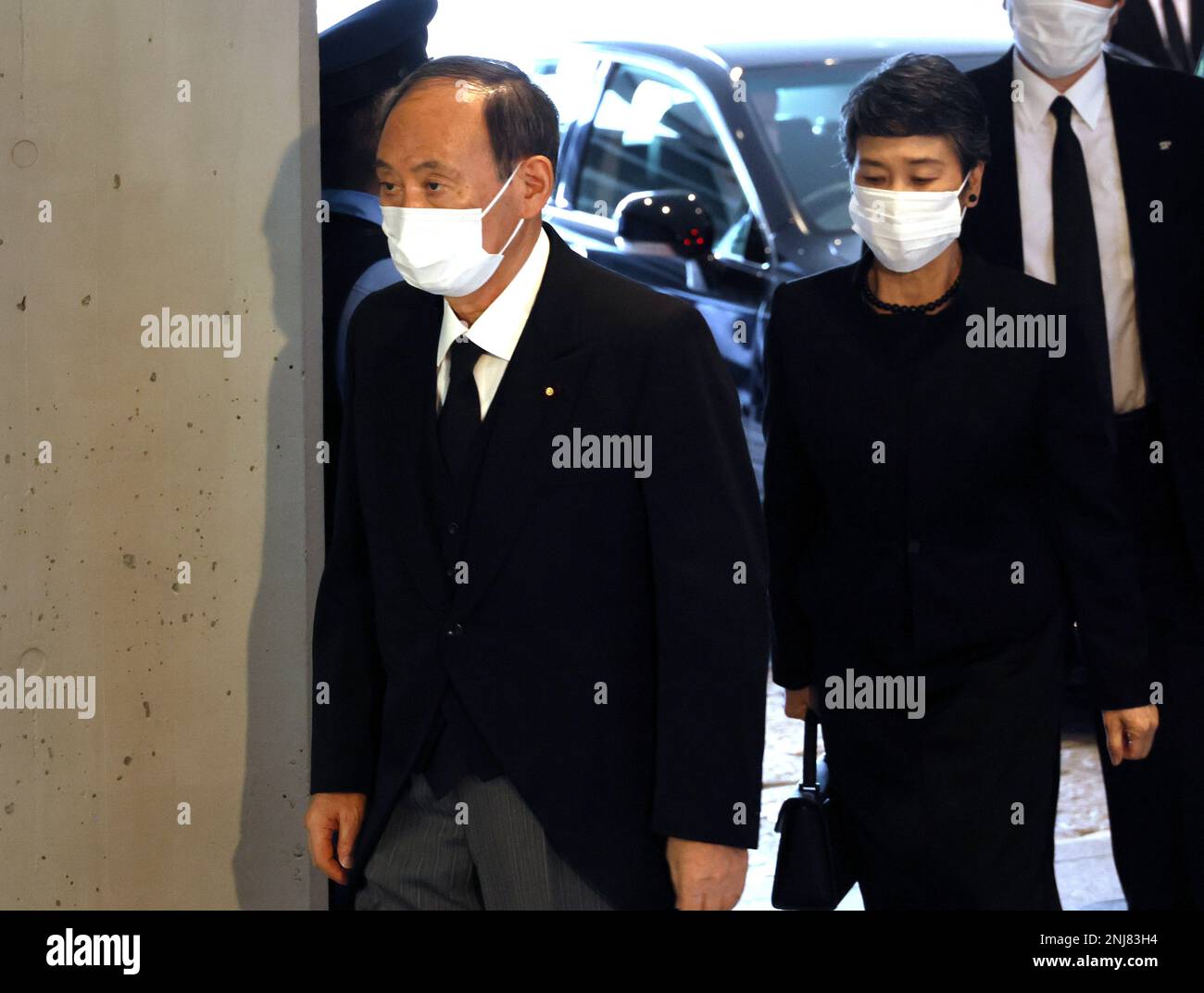 Former Japanese Prime Minister Yoshihide Suga, left, accompanied by his ...