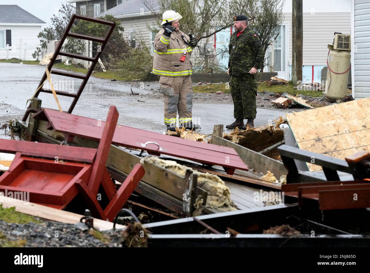 Warrant Officer 1st Class Bradley McInnes speaks with a firefighter ...