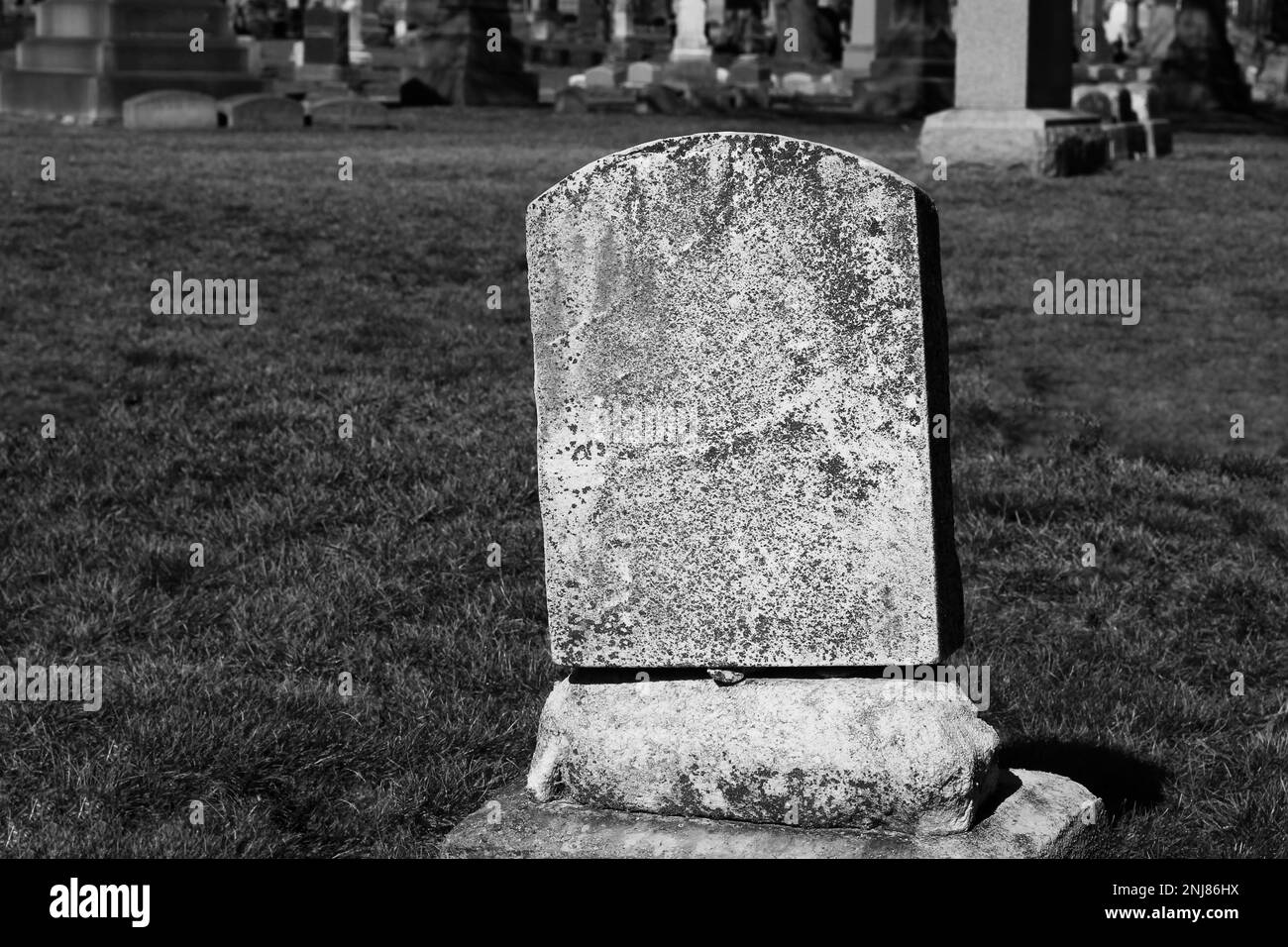 A worn and weathered old tombstone with a blank epitaph and room for ...
