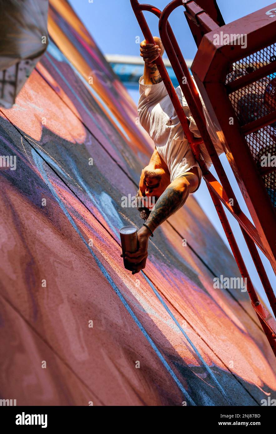 Ryan "Yanoe" Sarfati uses spray paint on the public art mural "Together ...