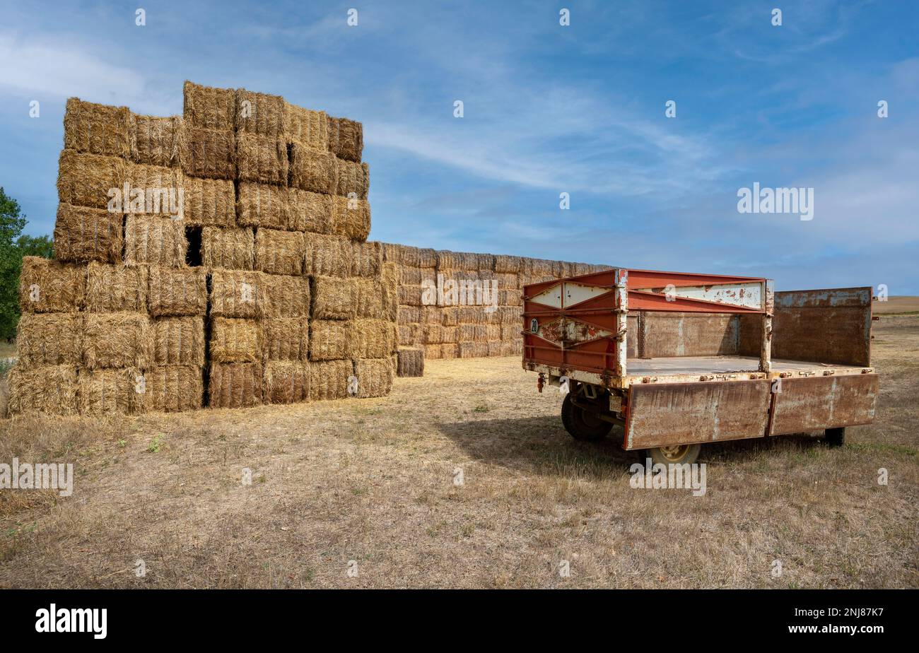 Rural Spanish landscape featuring stacks of hay bales next to an old ...