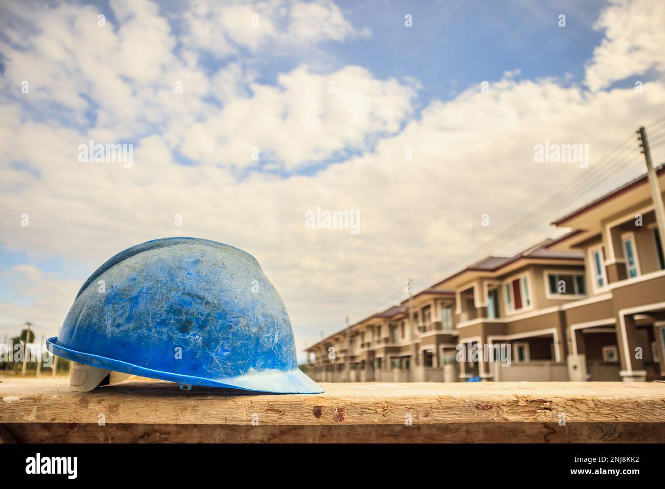 Blue hard hat on house building construction site Stock Photo - Alamy