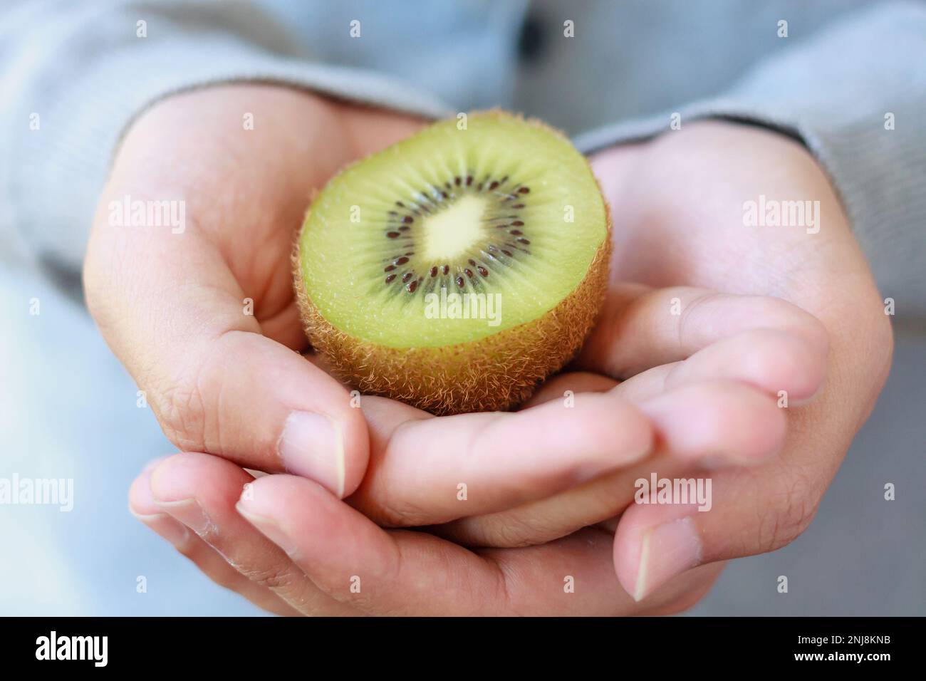 holding fresh kiwi fruit in hands Stock Photo - Alamy