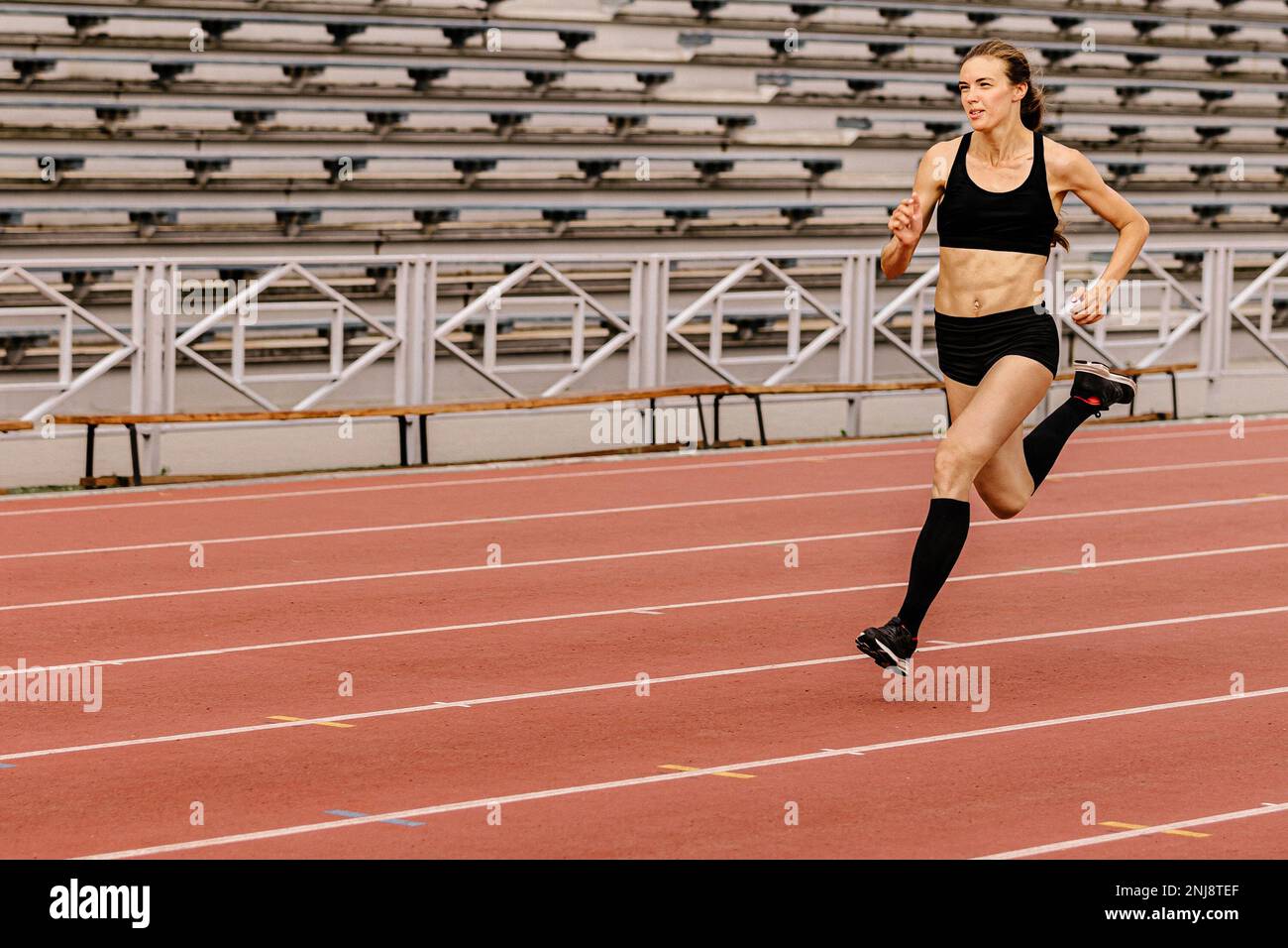 female runner running on stadium track Stock Photo - Alamy