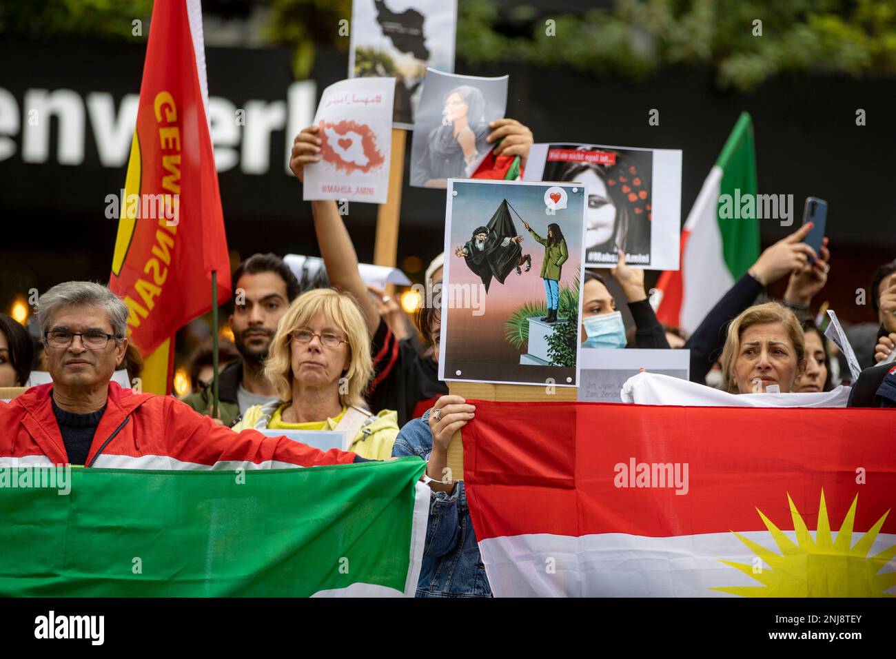 People hold flags during a protest over the death of Mahsa Amini, a ...