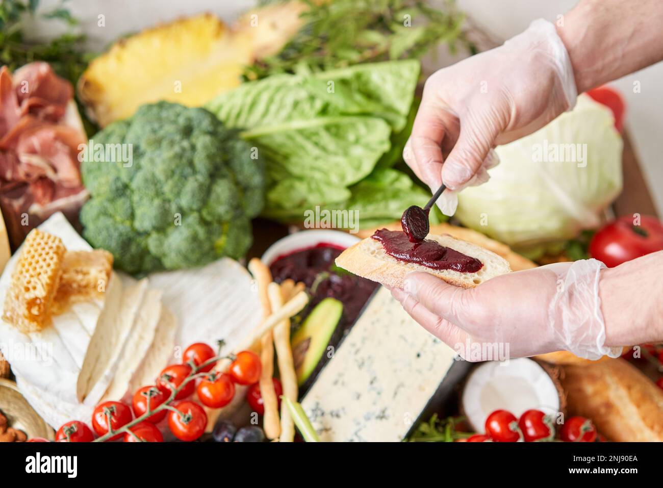 The waiter makes bruschetta or tapas. Table full of mediterranean ...