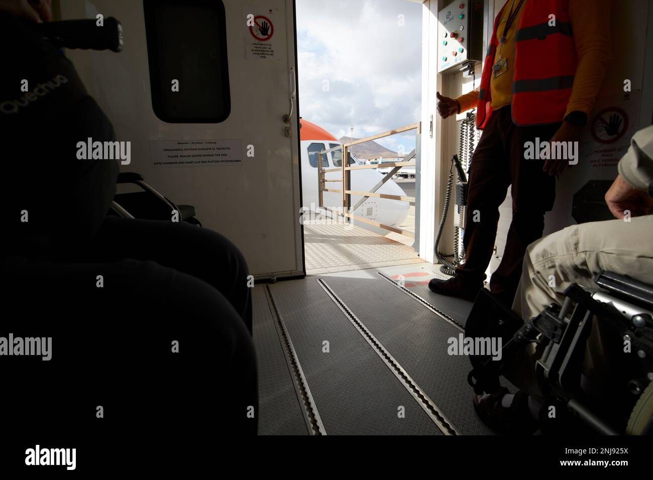 crew member showing wheelchair bound passengers how to access disabled ...