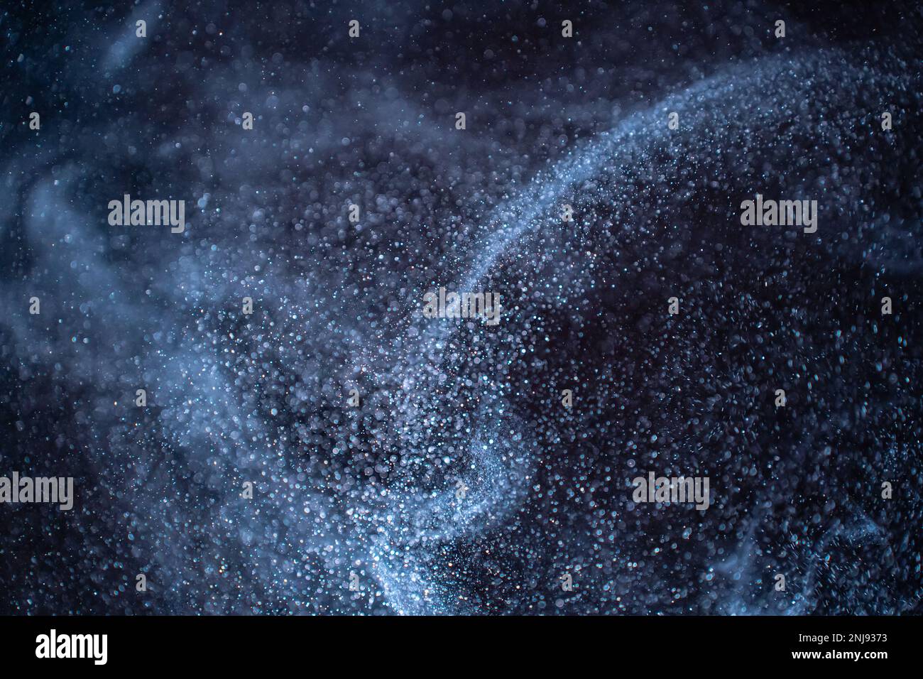 Dust particles cloud generating abstract shape on black background with ...