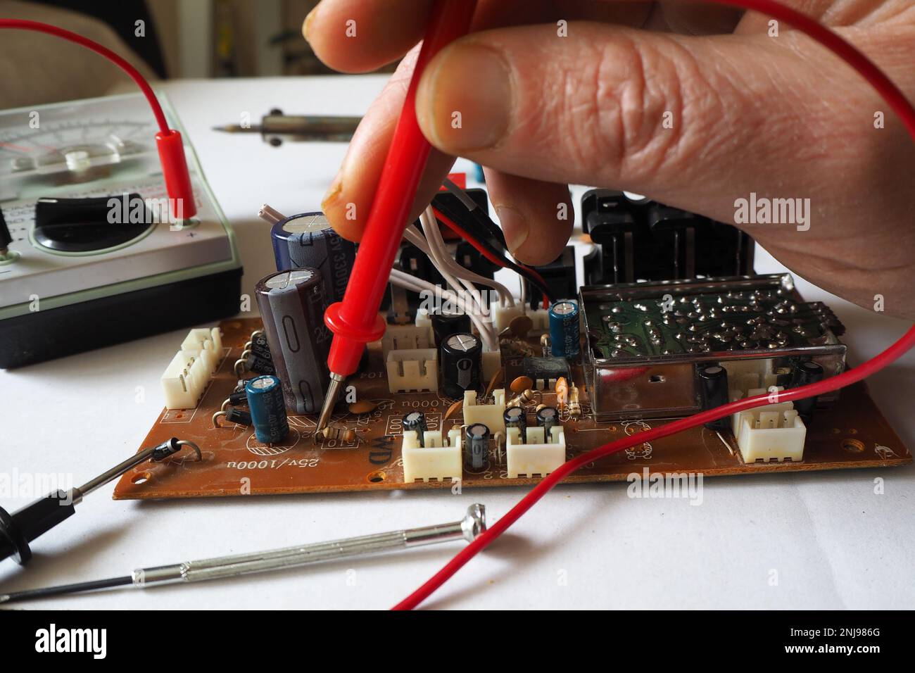 Troubleshooting on the smartphone's motherboard. Electronics technician repairing broken mobil ...